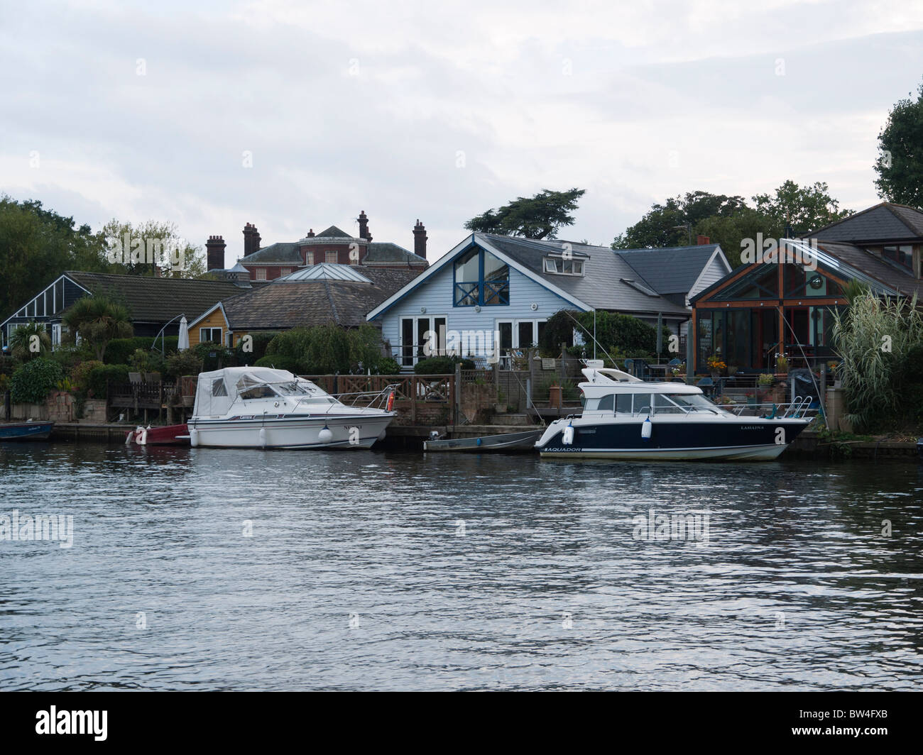 the good life - boats moored outside houses on the river Thames at ...