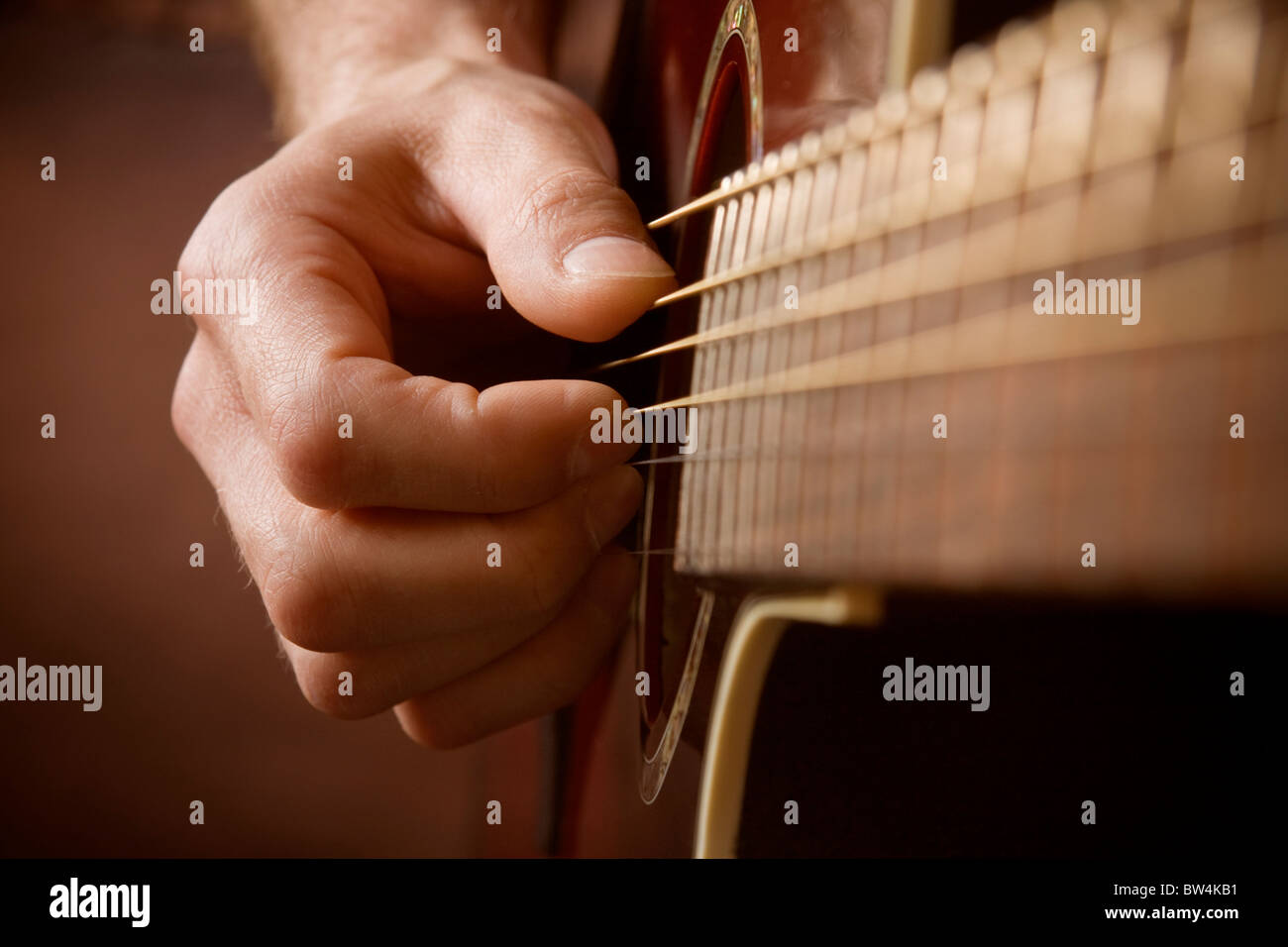 Guitarist playing acoustic guitar Stock Photo - Alamy