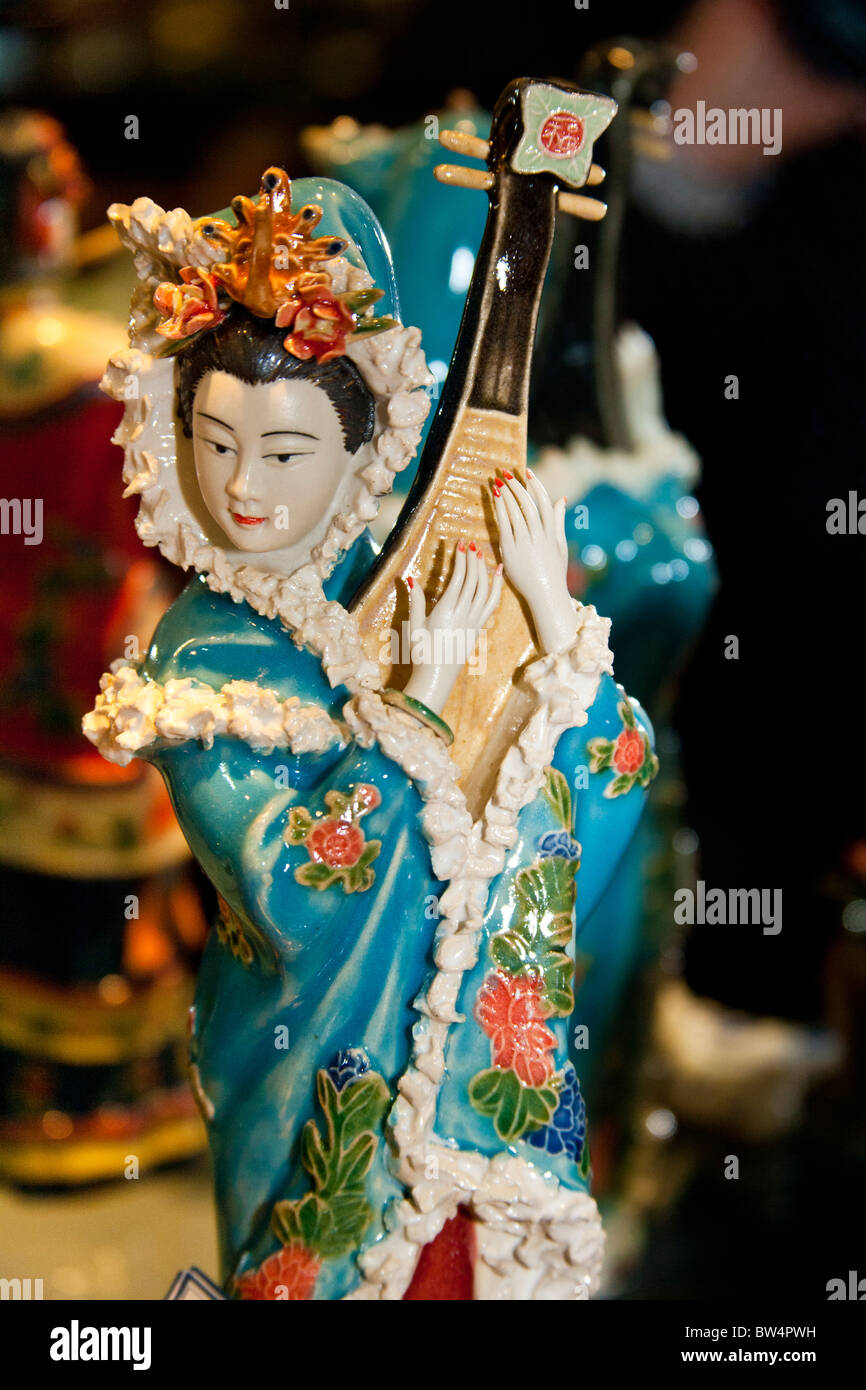 Painted jade carving of a Chinese woman playing a musical instrument ...