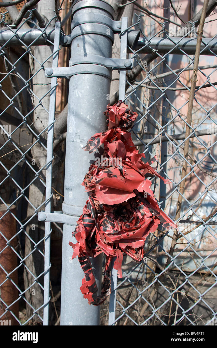 Plastic perimeter warning tape bunched up and stuffed in a fence Stock ...