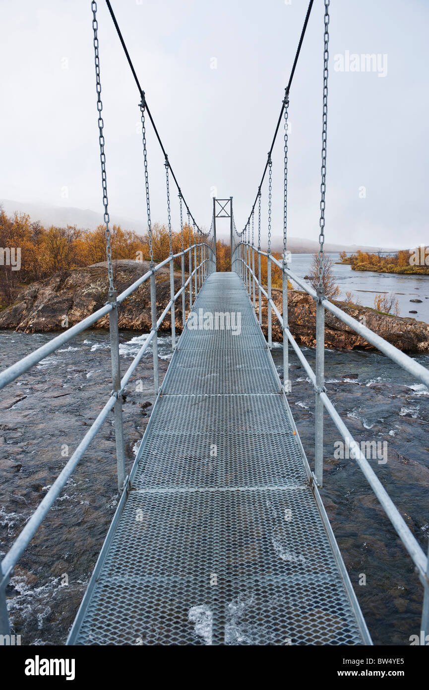 Hanging footbridge over river to Abiskojaure hut, Kungsleden trail ...
