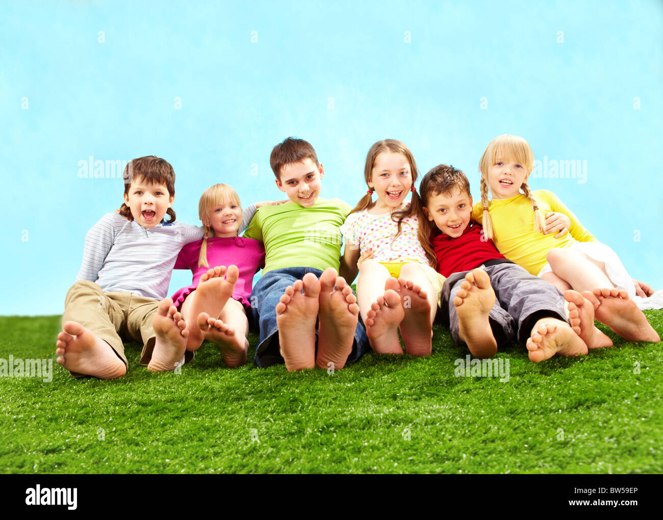 Group of happy children relaxing on the grass together Stock Photo - Alamy