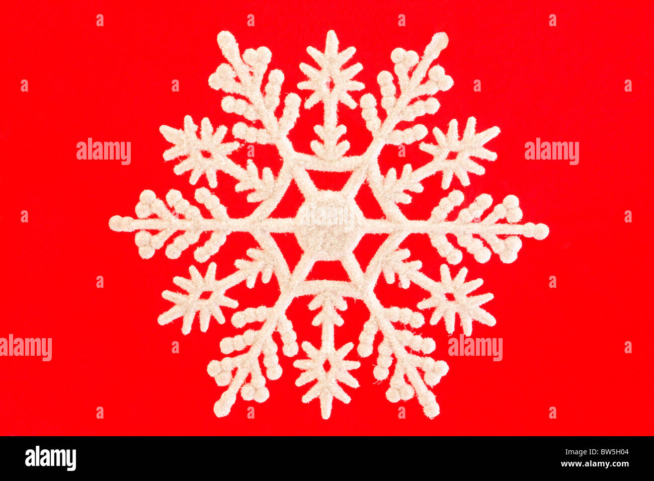 single white snowflake isolated over red Stock Photo - Alamy