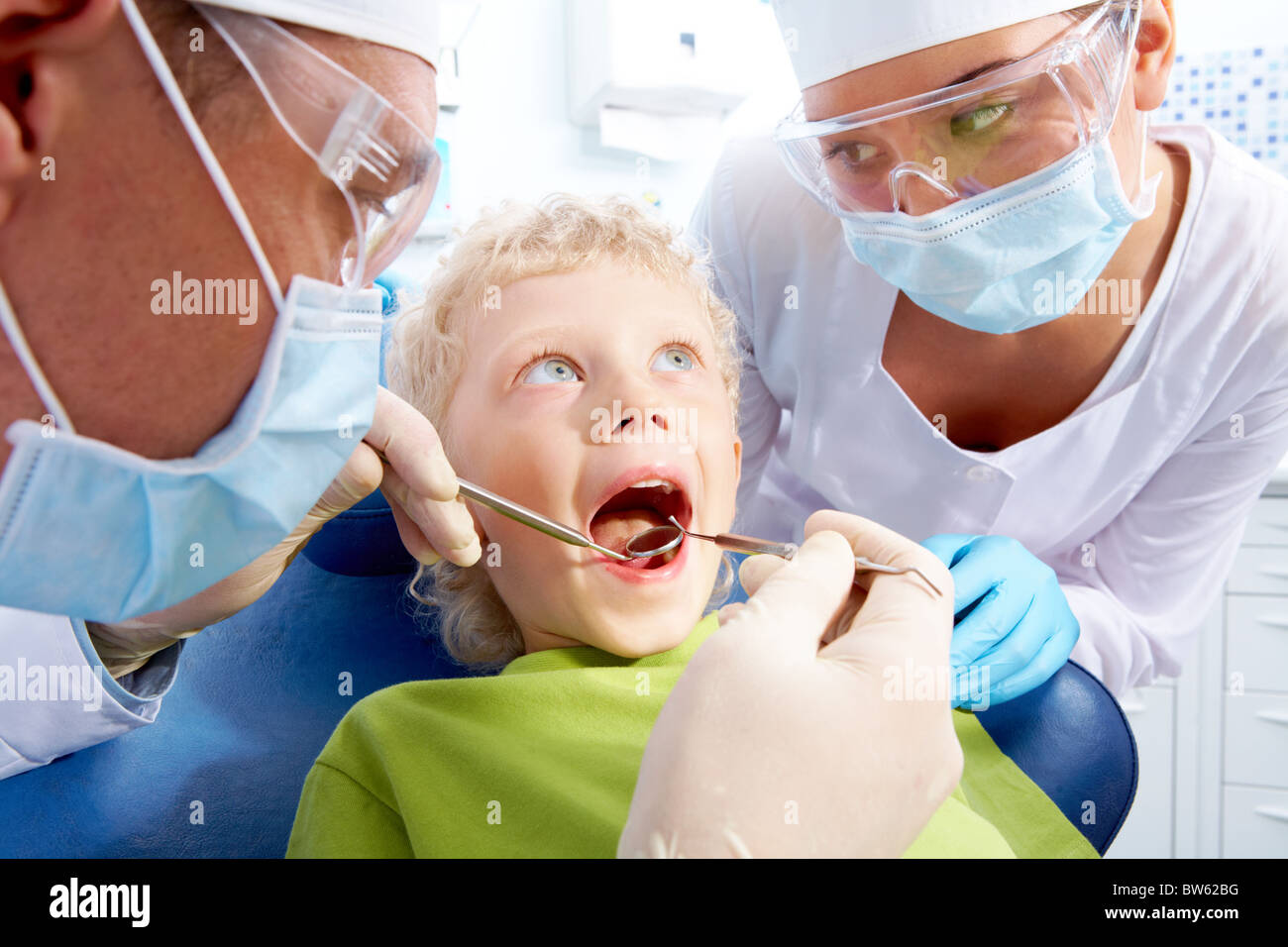 Image of little boy having teeth checked by doctor and assistant Stock ...