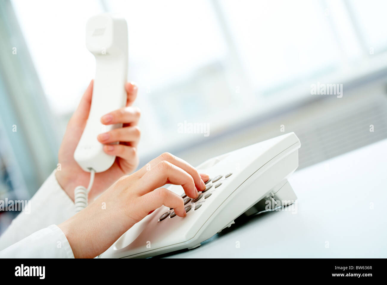 Photo of female hands dialing on white telephone Stock Photo - Alamy