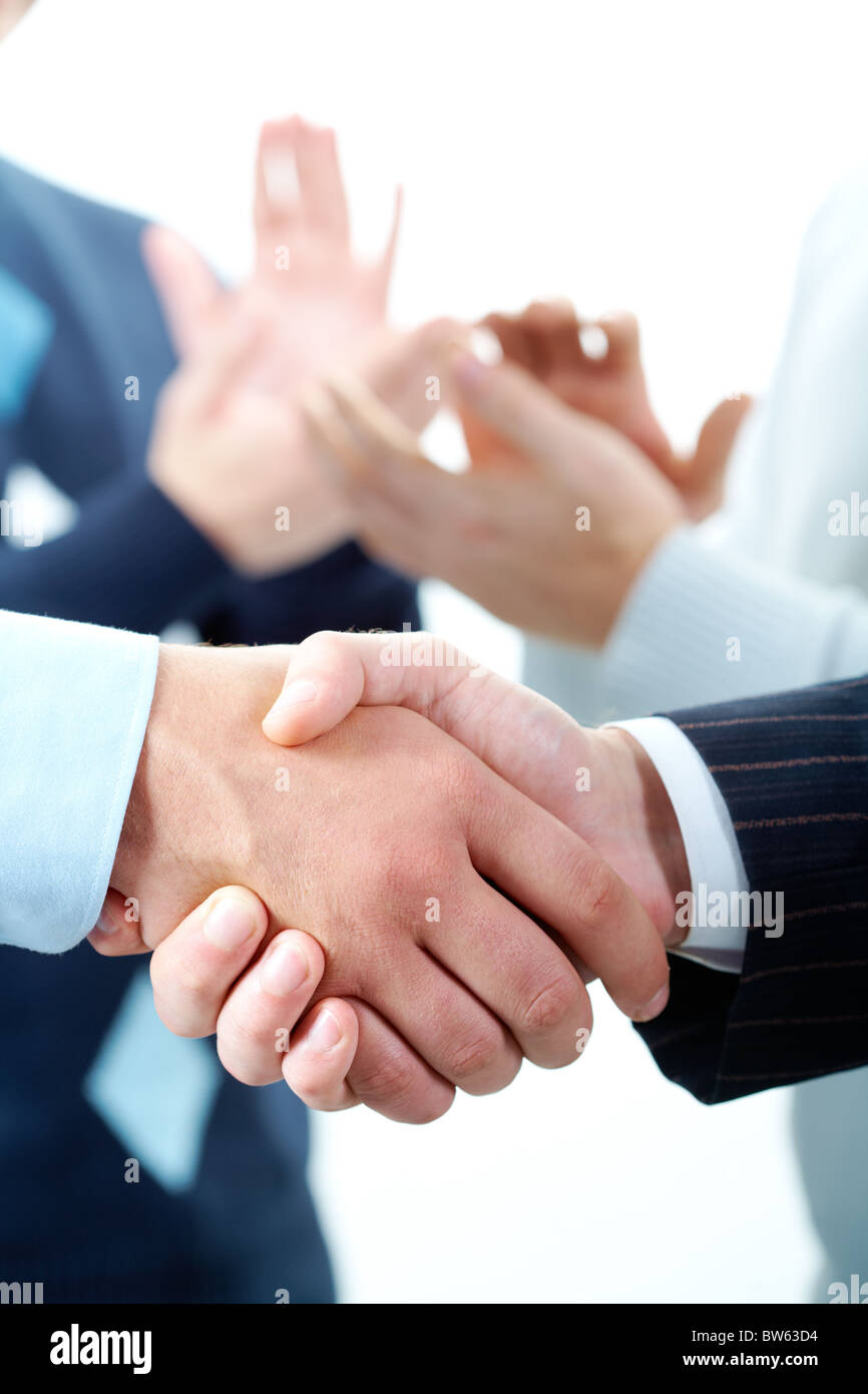 Vertical image of handshake on the background of applause of colleagues ...