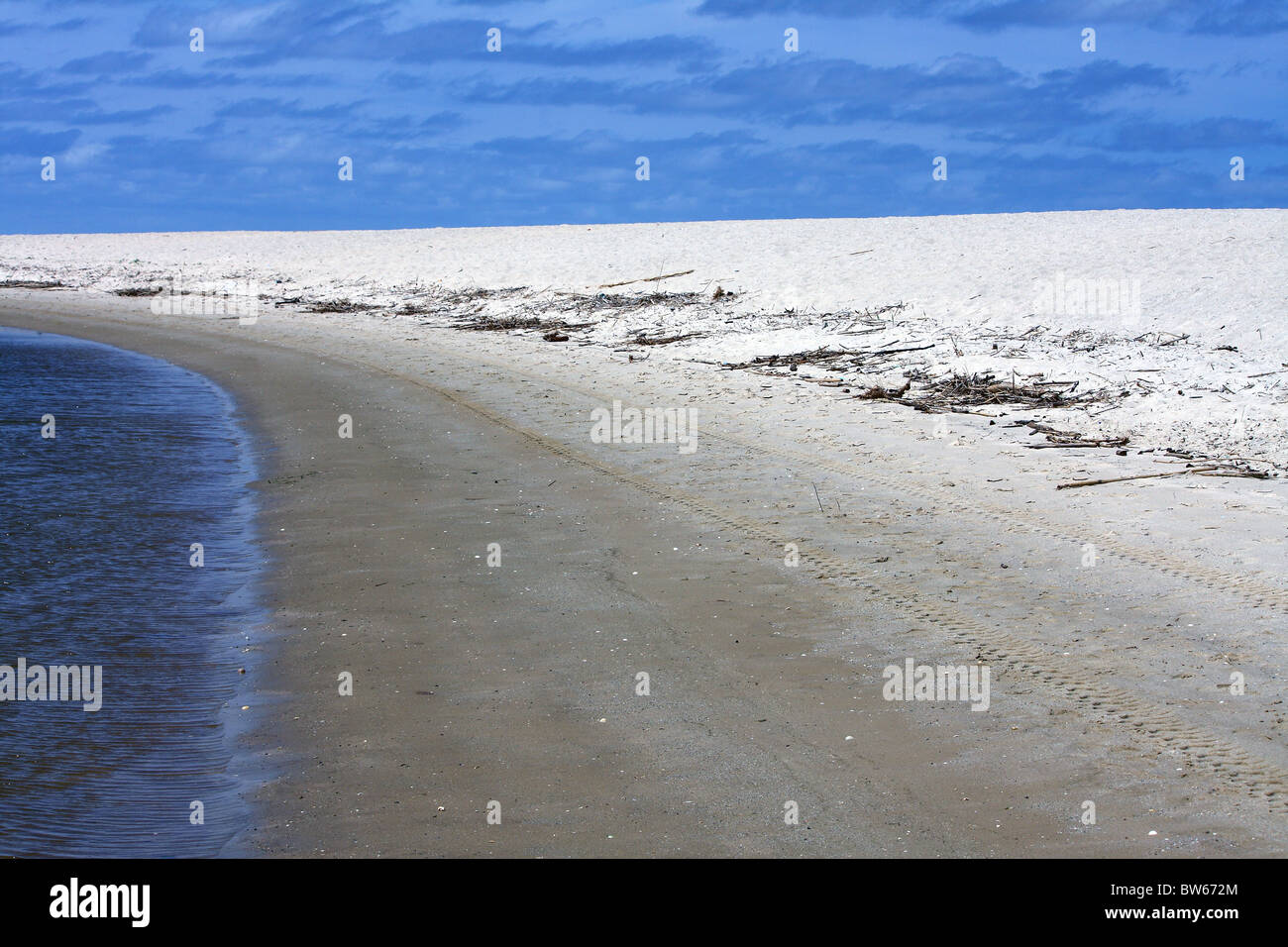 The deep blue sea, golden sandy beach and bright sunny blue skies in ...