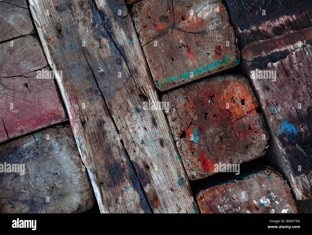 Rough cross cut timber stained with paint and wood stain in a shipyard ...