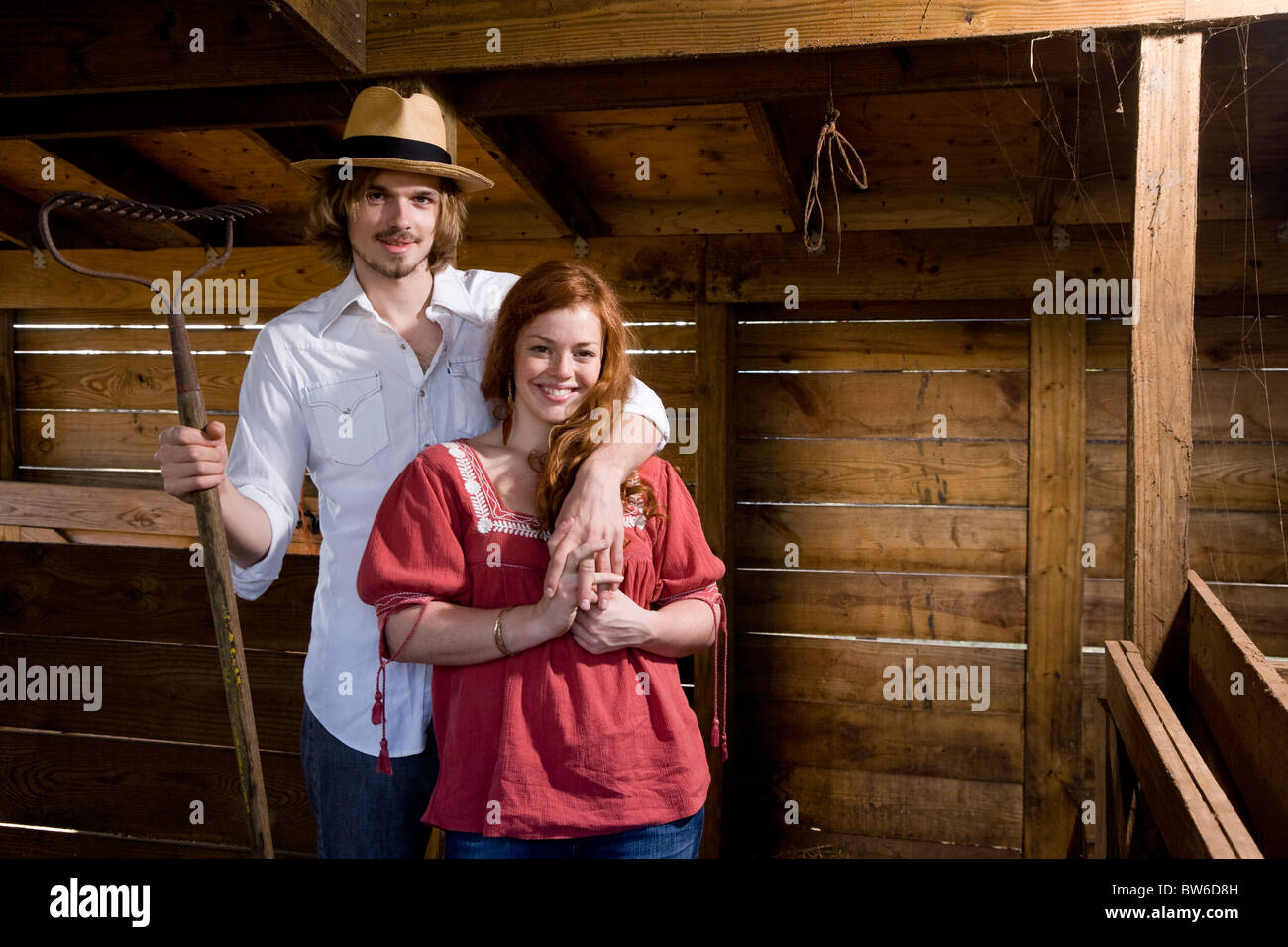 Young couple on farm standing inside barn Stock Photo - Alamy