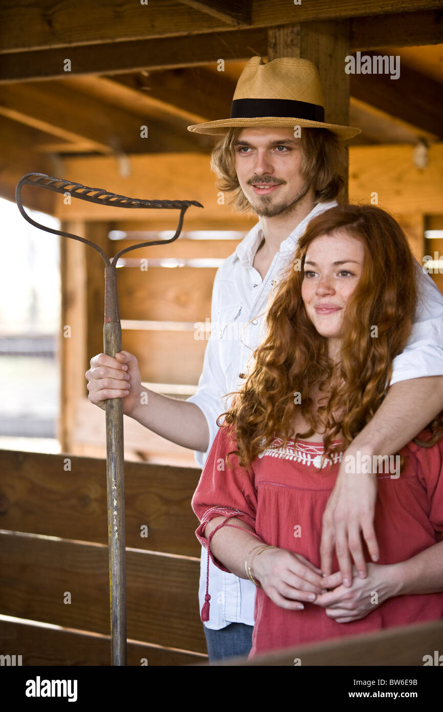 Young couple on farm standing inside barn Stock Photo - Alamy