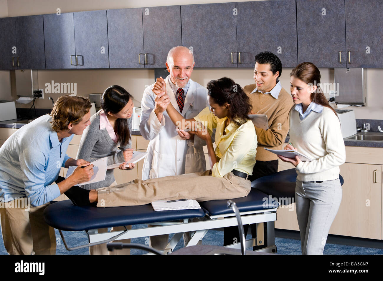 Medical school professor teaching students, examining patient Stock ...