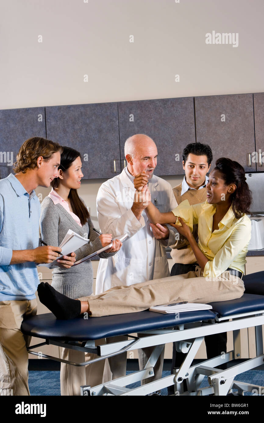 Students learning from medical school professor, practice on patient ...