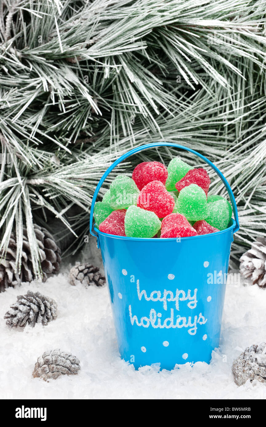 A decorative pail of Christmas candy in a snowy wilderness. Open space for copy intentionally ...