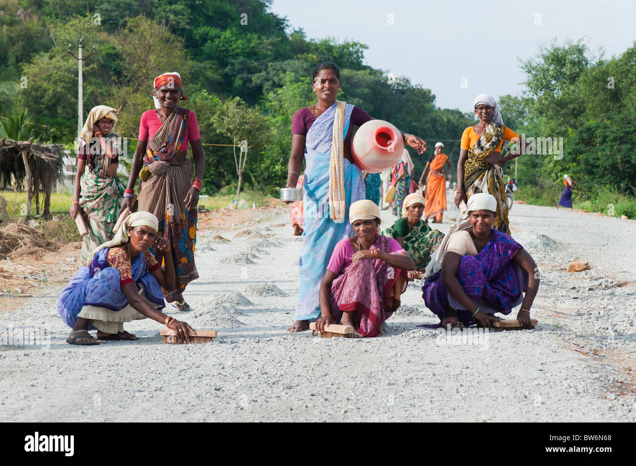 Gang of indian women road workers sweeping and picking up stones off a ...