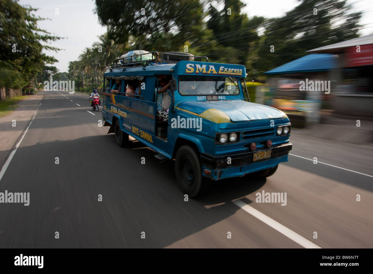 A jeepney travels along a highway near Dumaguete, Philippines Stock ...