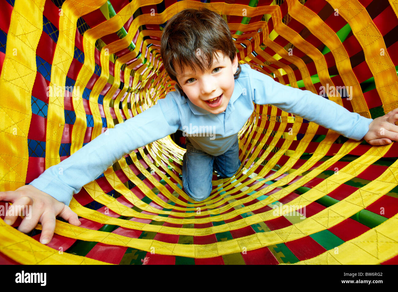 Happy lad looking at camera while having fun inside toy tunnel Stock ...