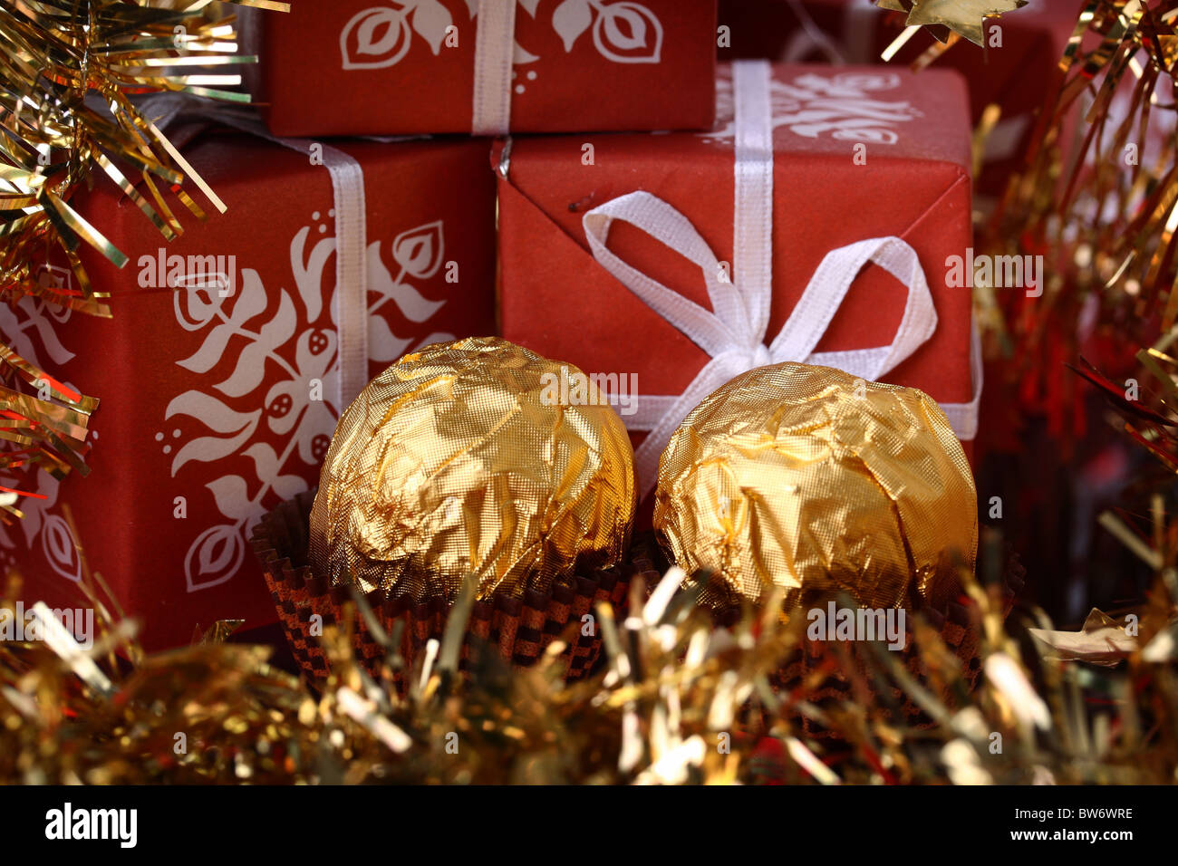 Three gift boxes and two golden luxury golden sweets Stock Photo - Alamy