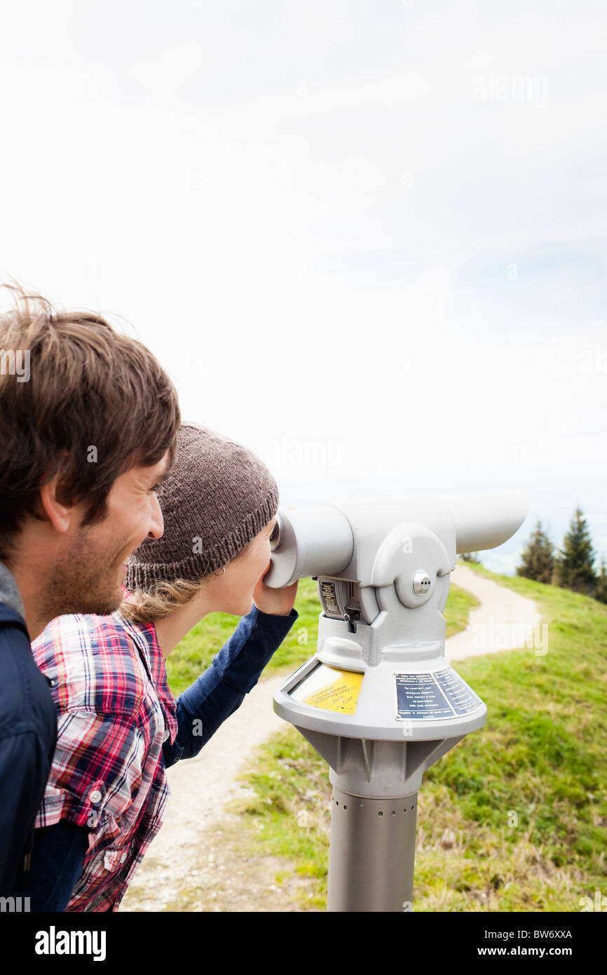 Couple using telescope Stock Photo - Alamy