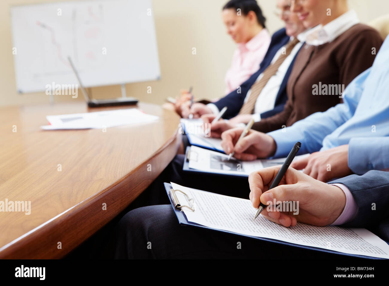 Partners writing something at meeting Stock Photo - Alamy