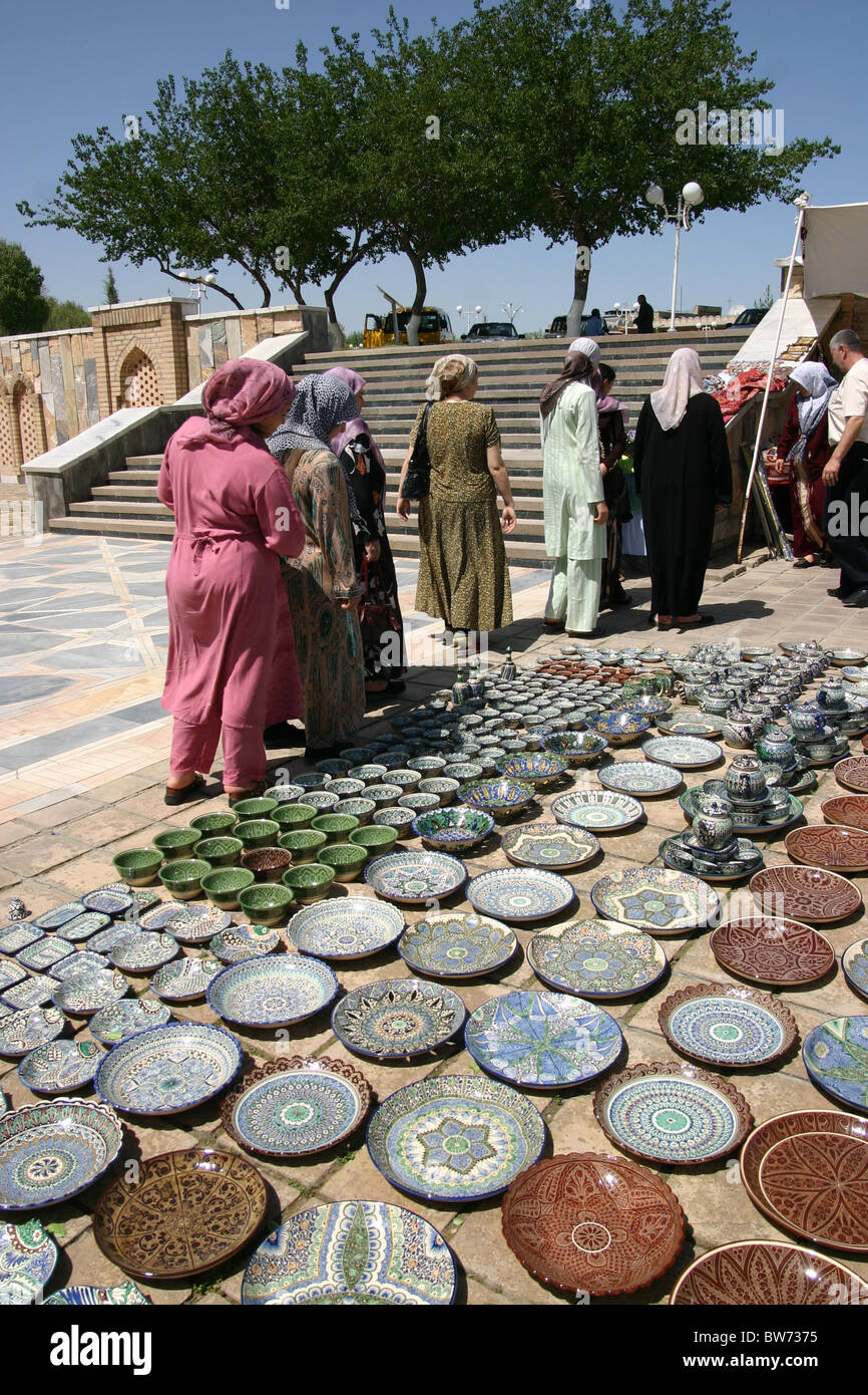 Traditionally dressed ladies look at souvenirs in Samarkand, Uzbekistan ...