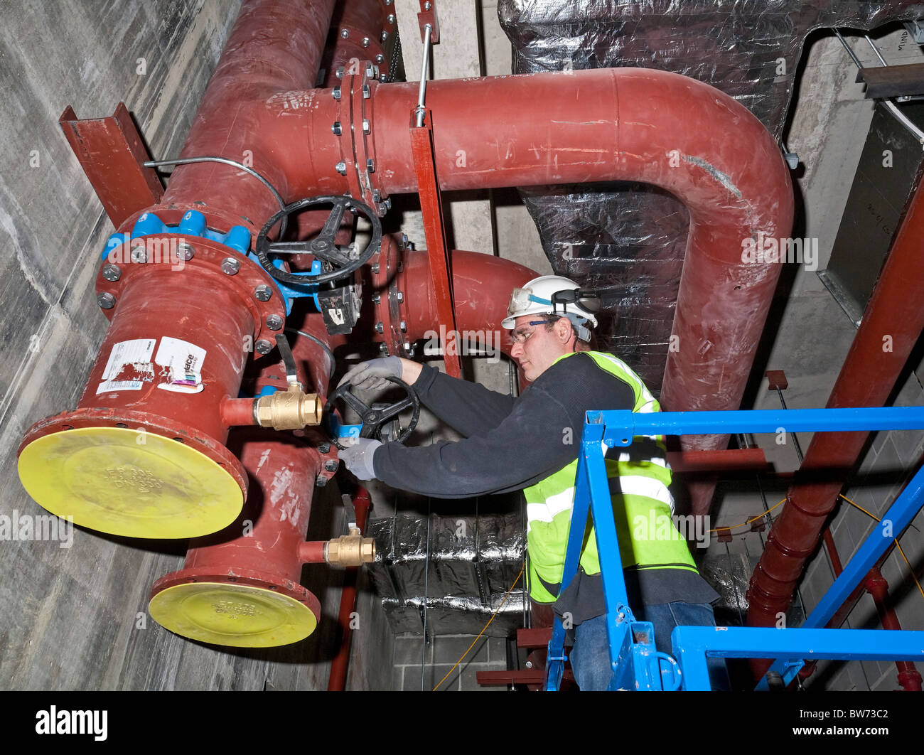 Building services engineer working on pipework on a building site Stock ...