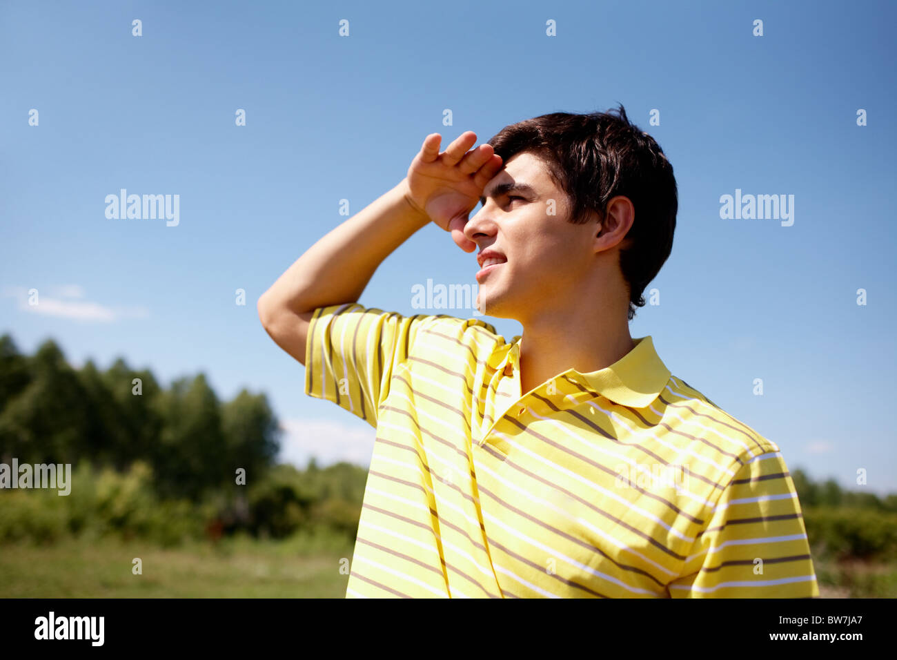 Photo of handsome man holding his hand near the forehead Stock Photo ...