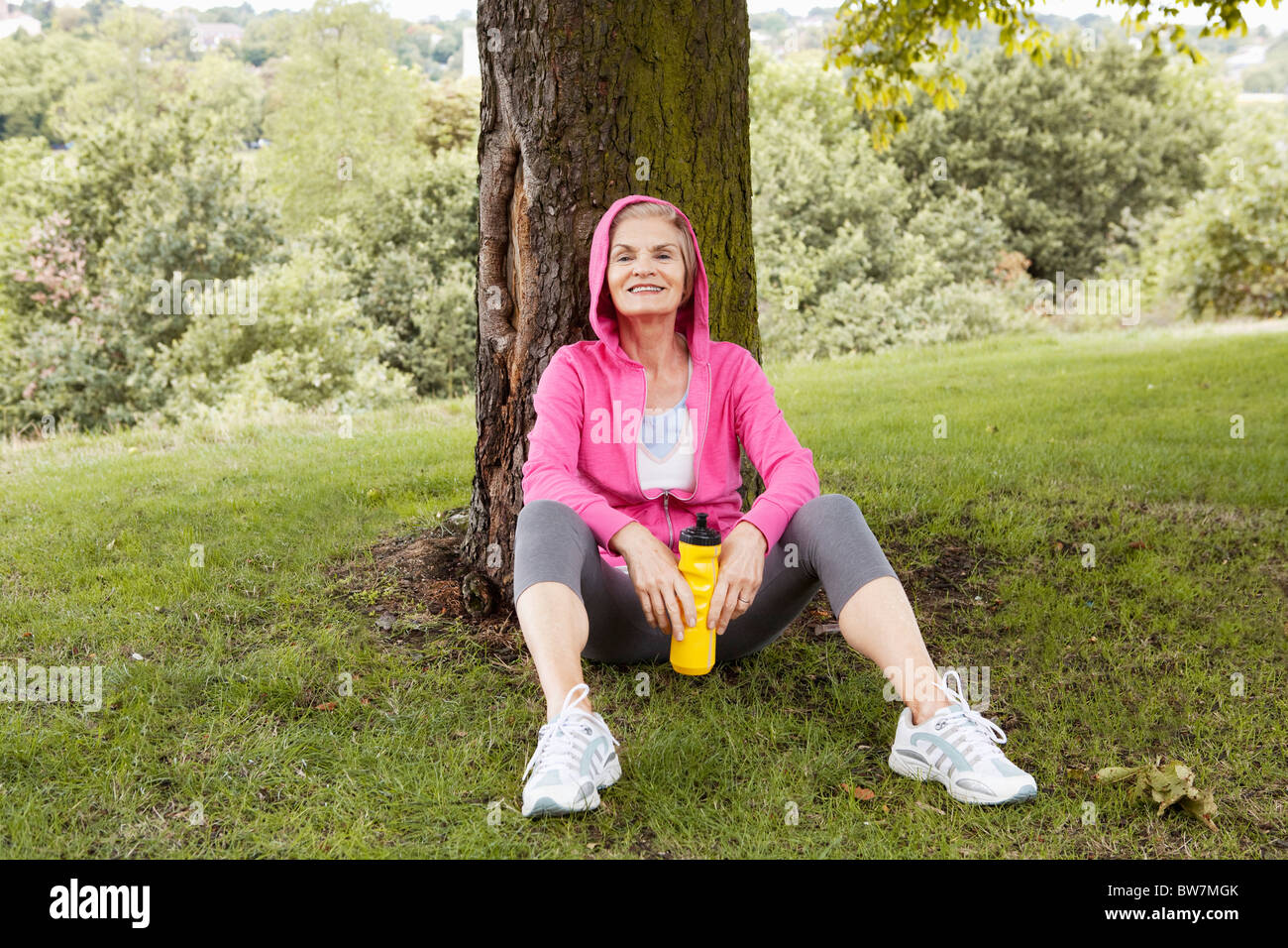 Woman Sitting Against Tree Trunk High Resolution Stock Photography and ...