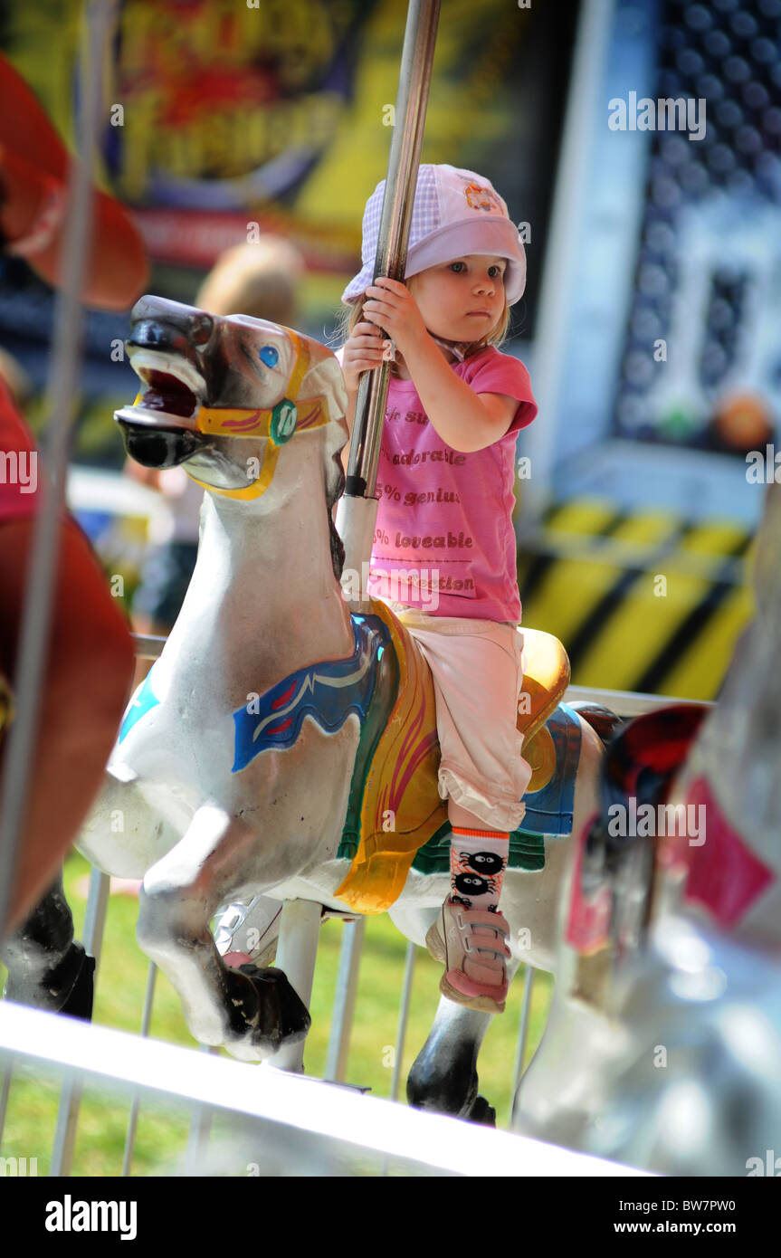 young child riding a merry-go-round at an agricultural fall fair Stock ...