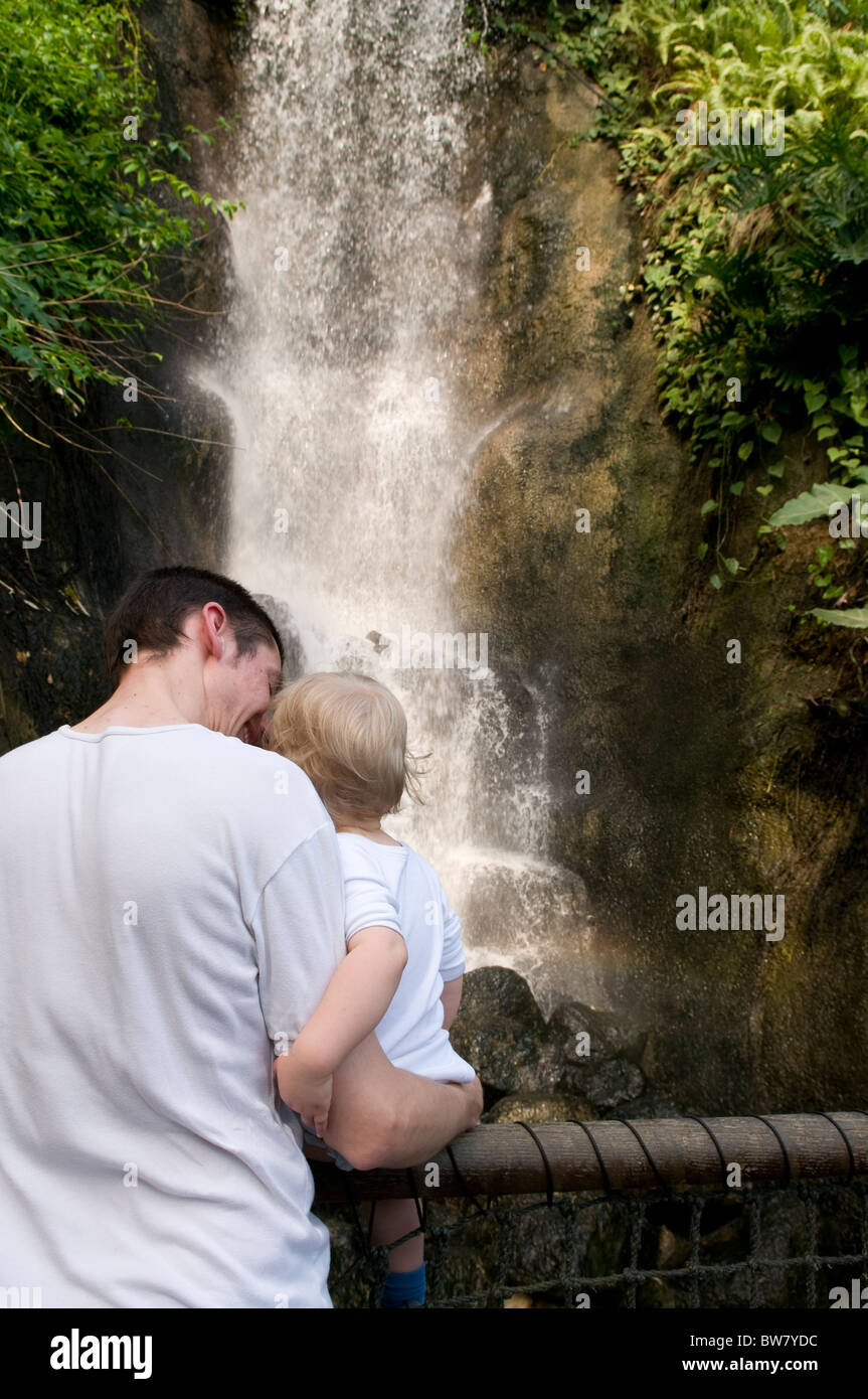 Back view of a father and baby looking at a waterfall Stock Photo - Alamy