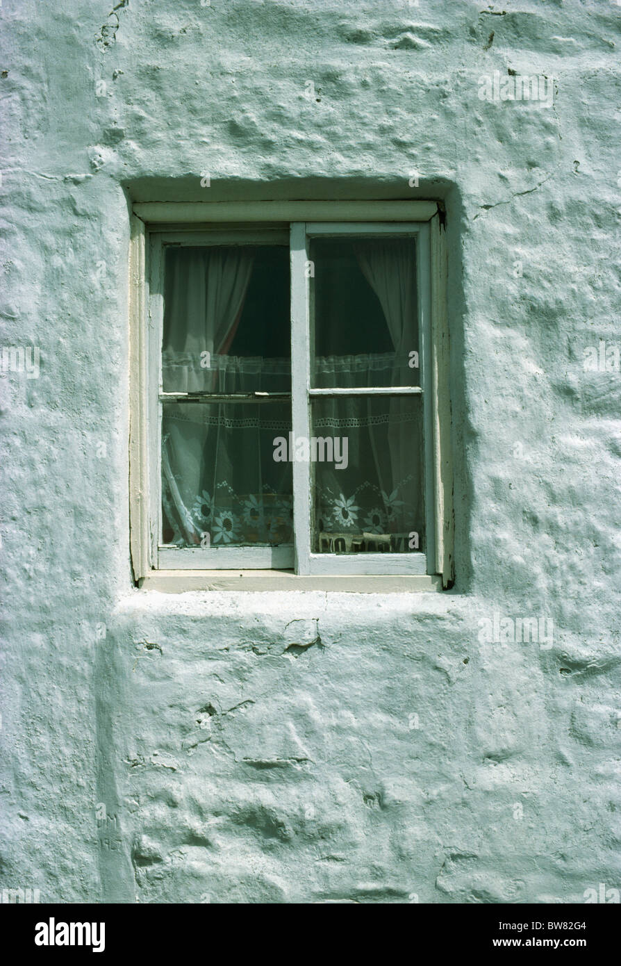 Close-up of traditional sliding window in white painted stone cottage ...