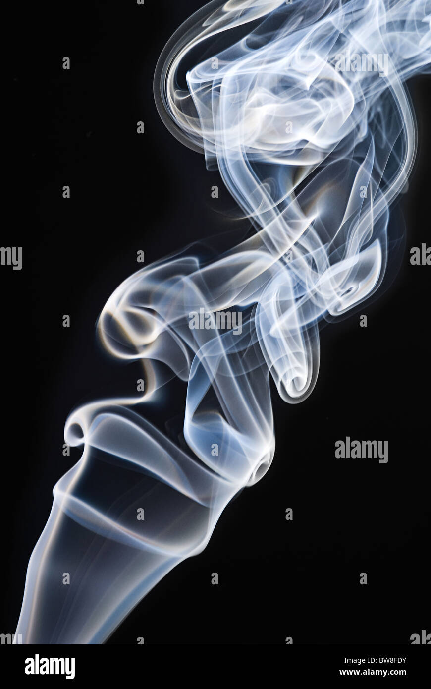 wavy smoke trail against black background creating patterns calmness ...