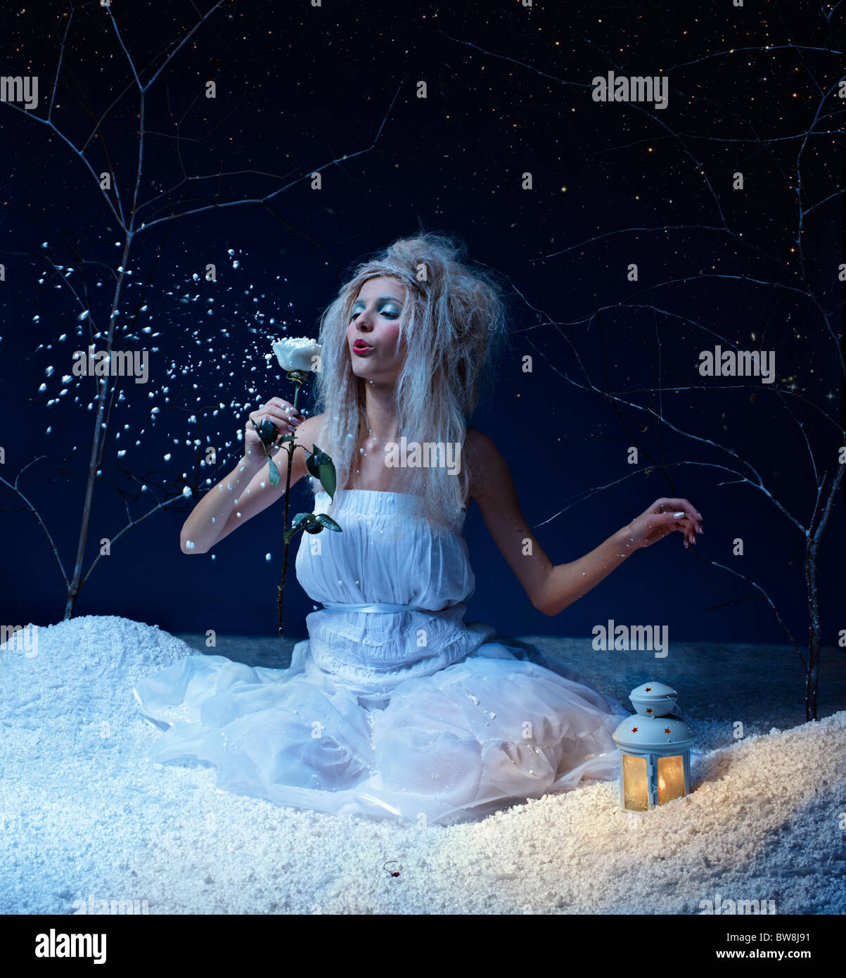 portrait of beautiful winter fairy nymph girl sitting on snow and ...