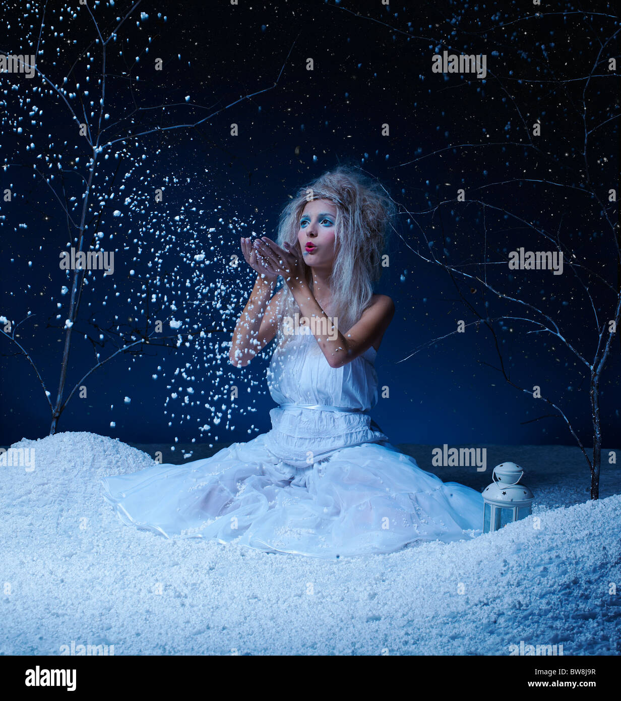 portrait of beautiful frozen fairy nymph girl sitting on snow and ...