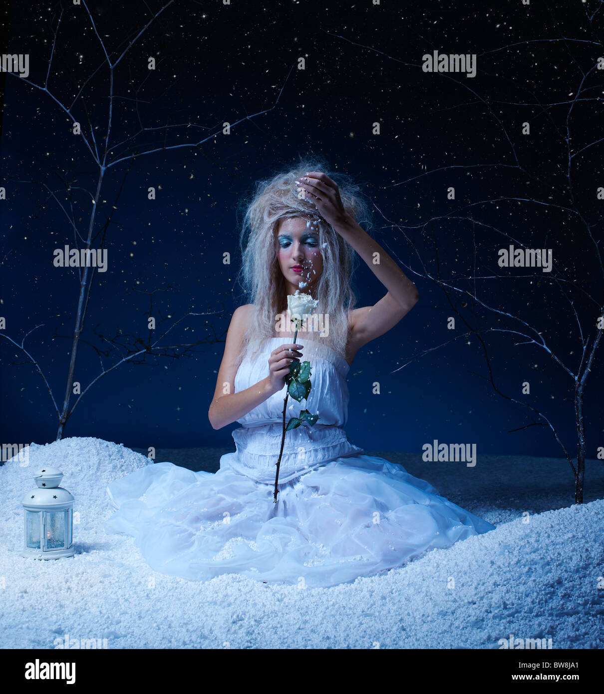 portrait of beautiful winter fairy nymph girl sitting on snow with ...