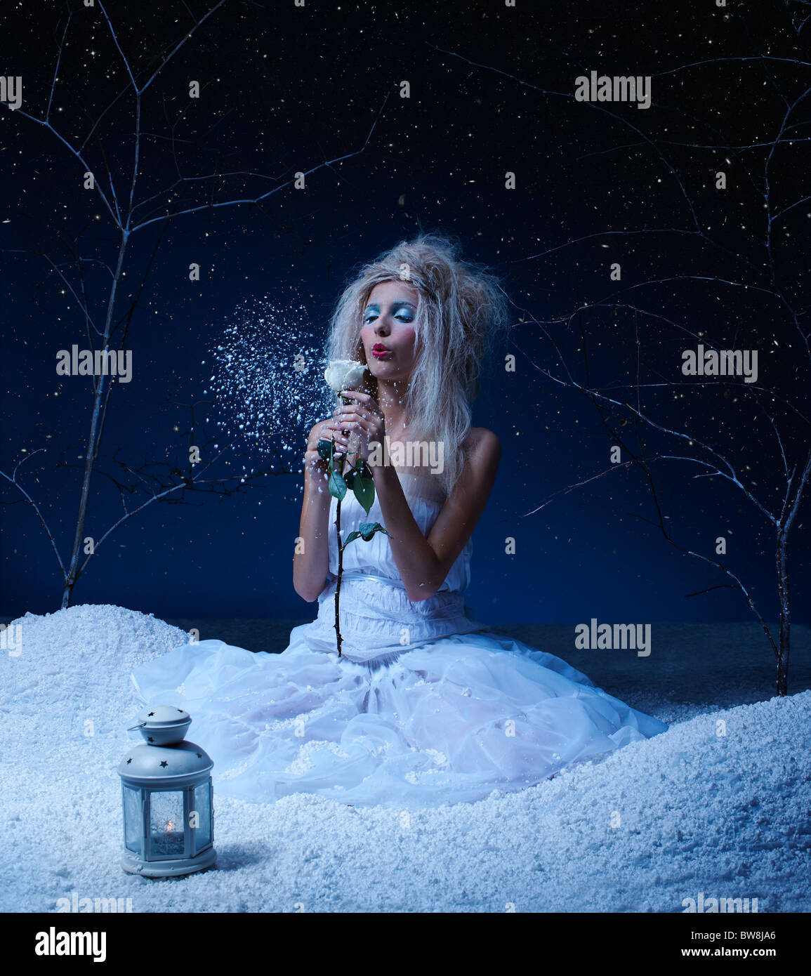 portrait of beautiful winter fairy nymph girl sitting on snow and ...