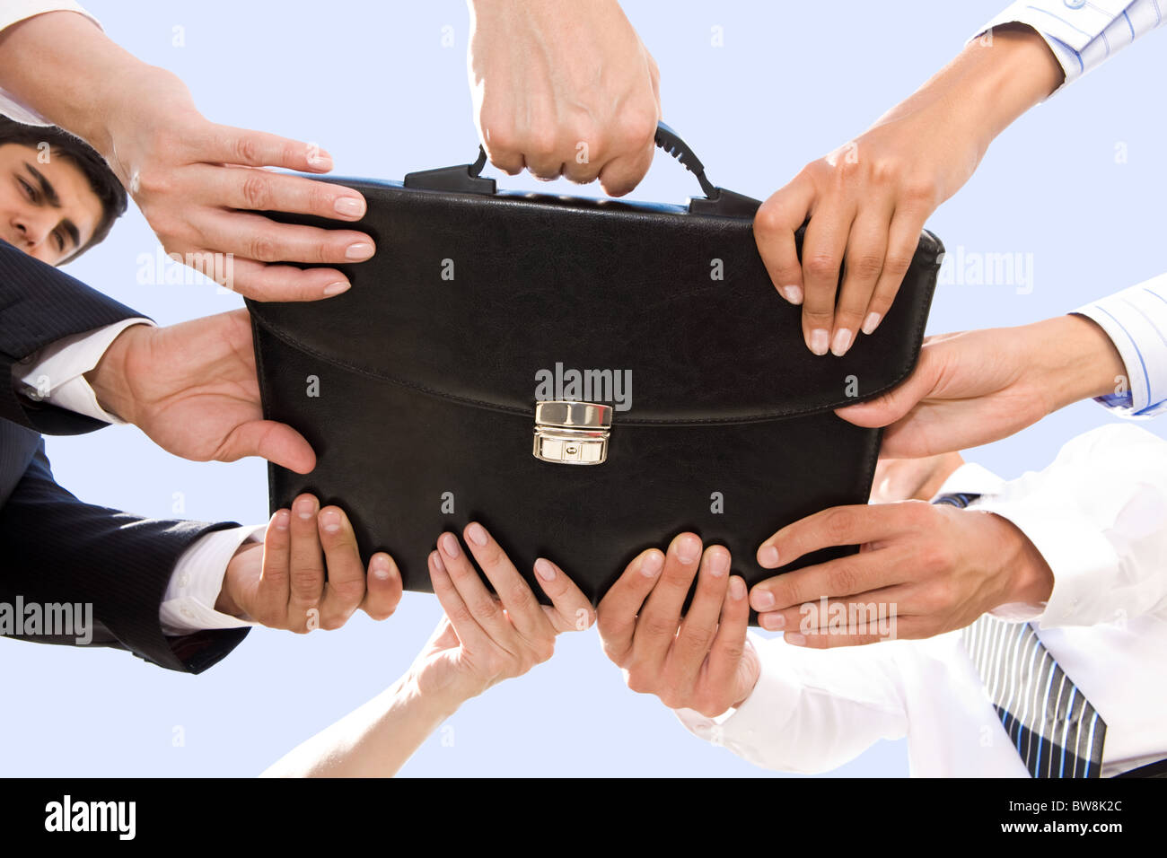 Below angle of people hands holding black leather briefcase ...