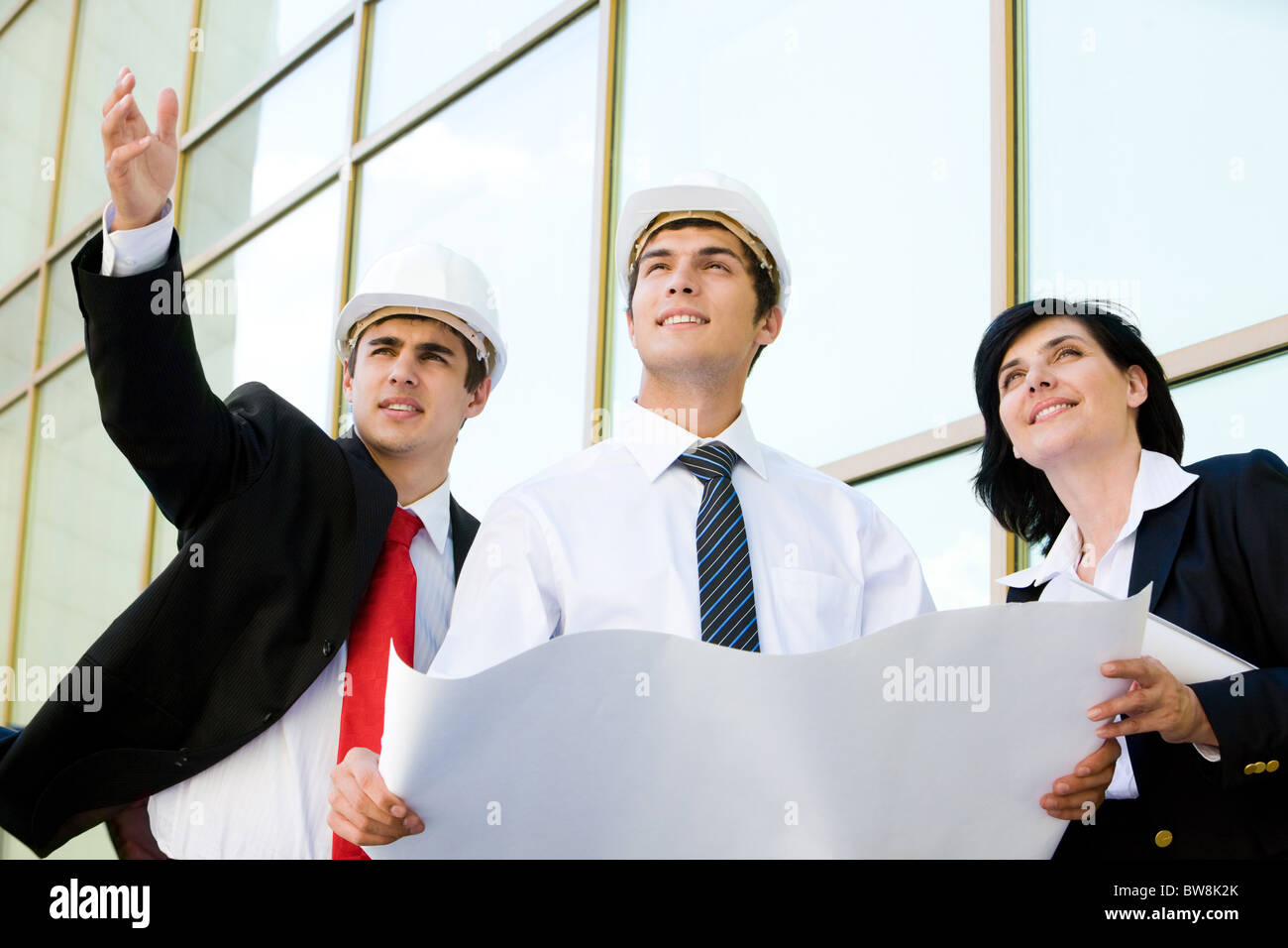 Confident worker pointing at something while explaining new project to ...