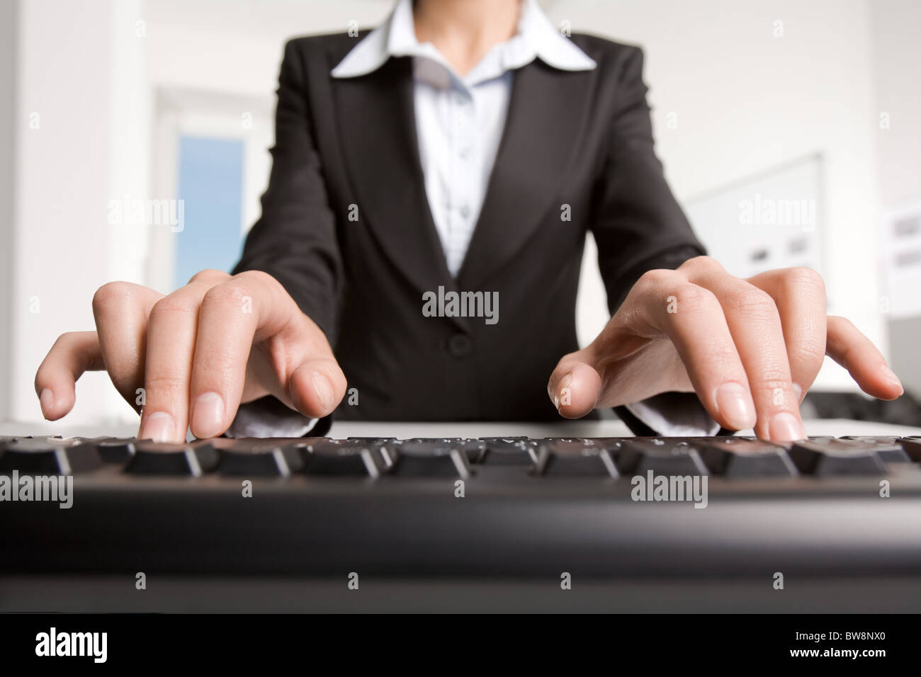 Close-up of businesswoman in black suit typing a letter Stock Photo - Alamy