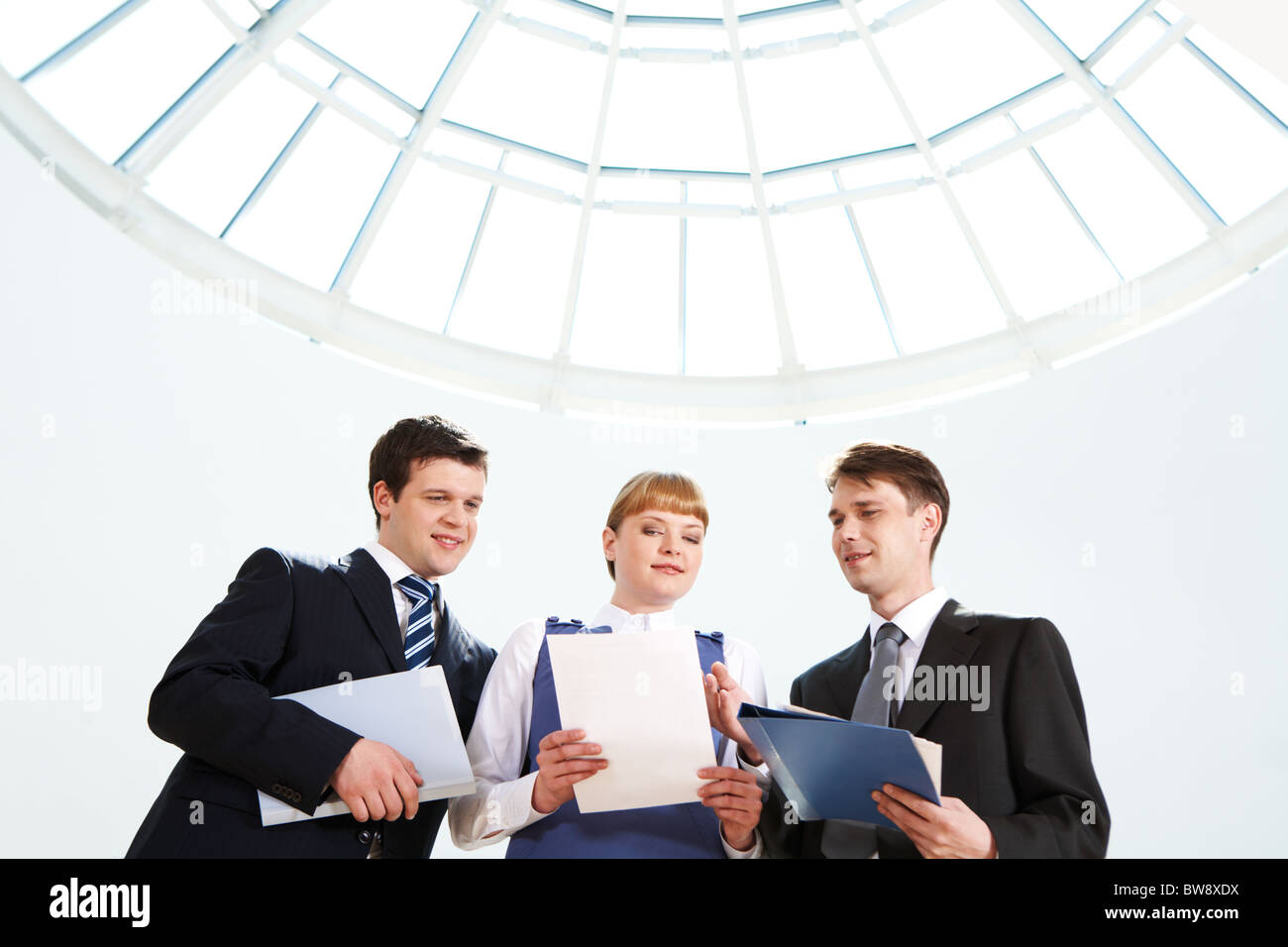Photo of confident business people looking at paper in female hand at ...