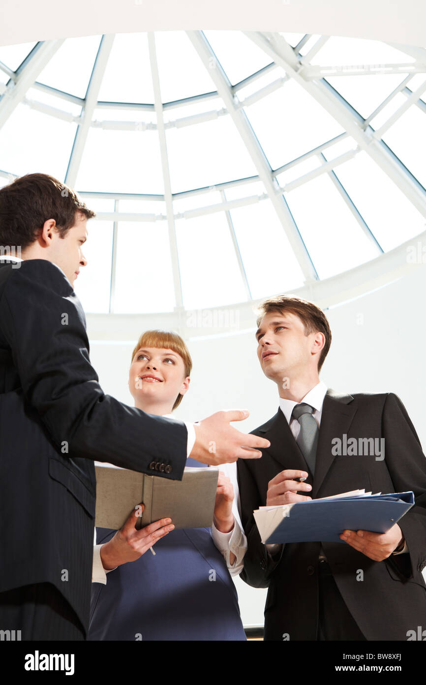 Image of smart professional explaining something to his colleagues at ...