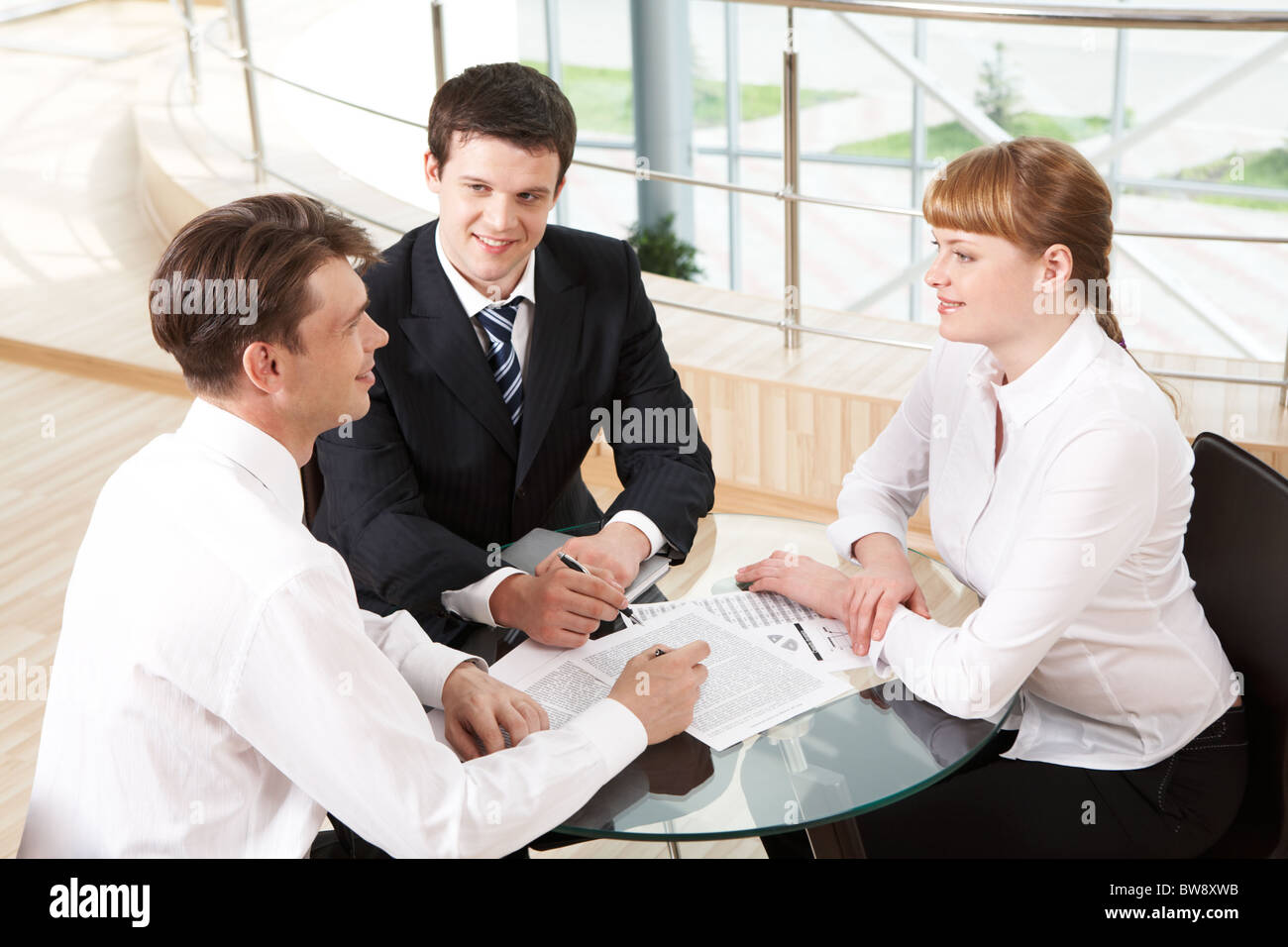 Photo of company of successful people discussing new project in office ...