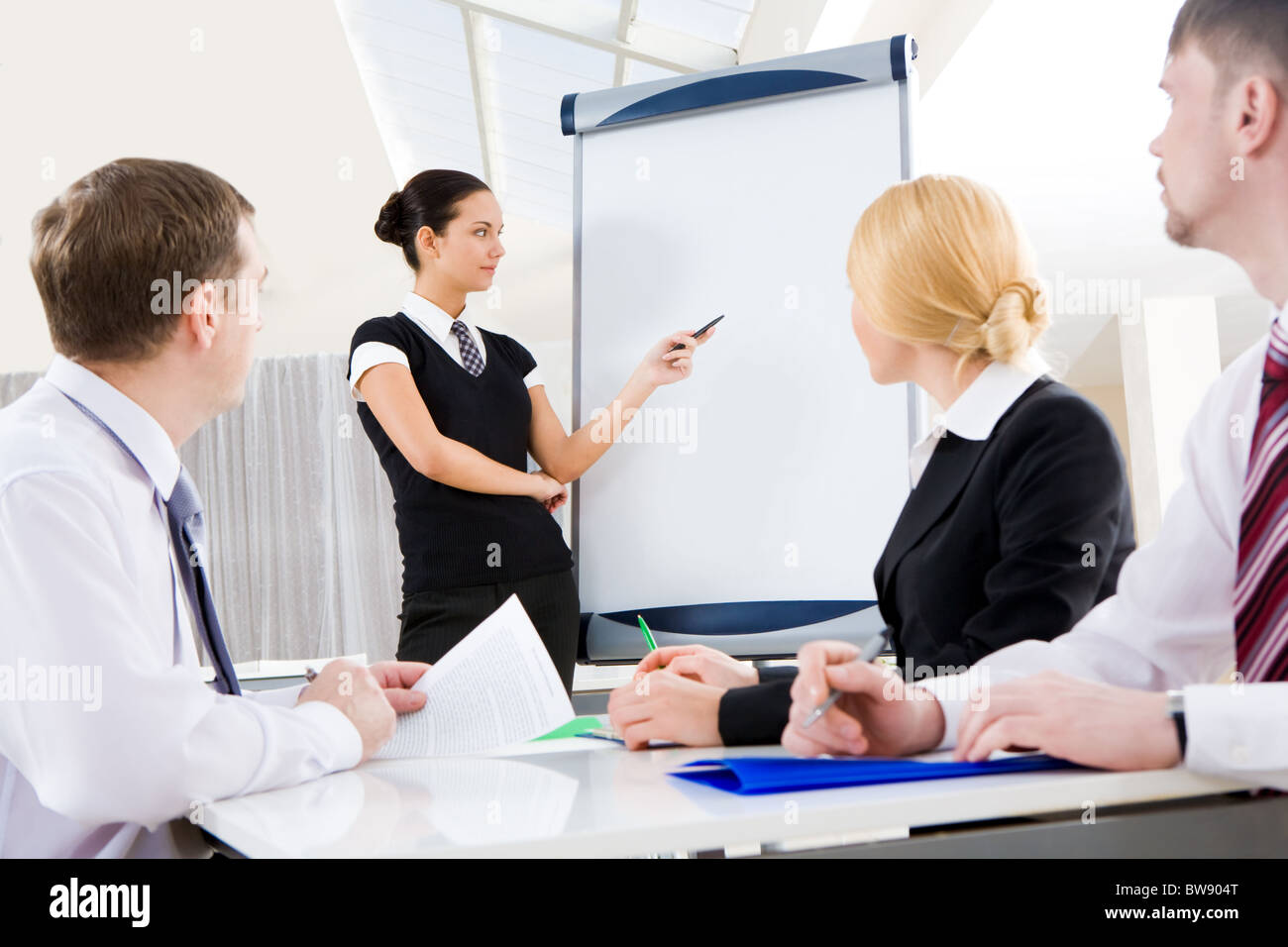 Smart and confident employee pointing at whiteboard while presenting ...
