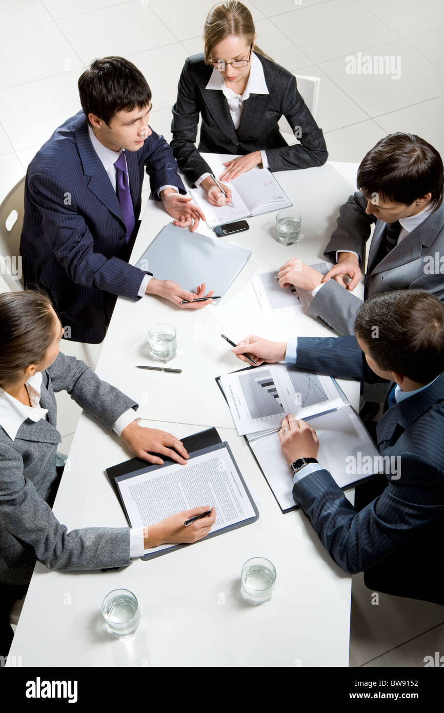 Team of several business people discussing an important question at ...