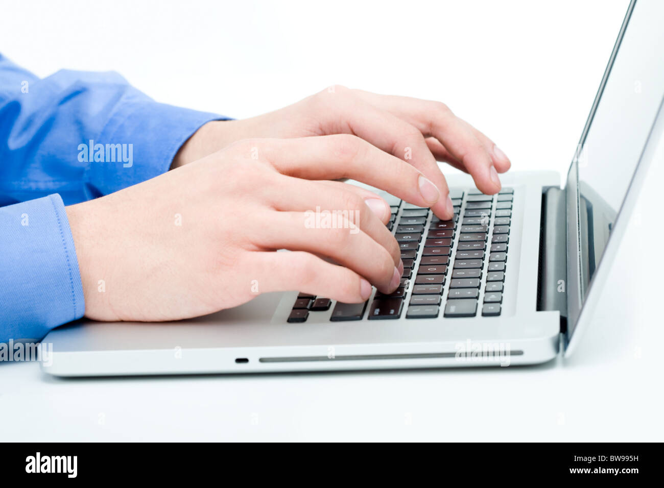 Close-up of male hand over silver keyboard of laptop during typing ...