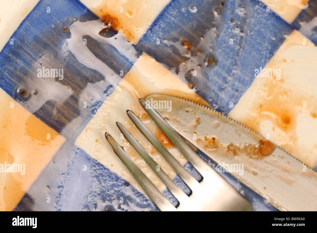 Knife and fork on an empty dirty plate after eating dinner meal Stock ...