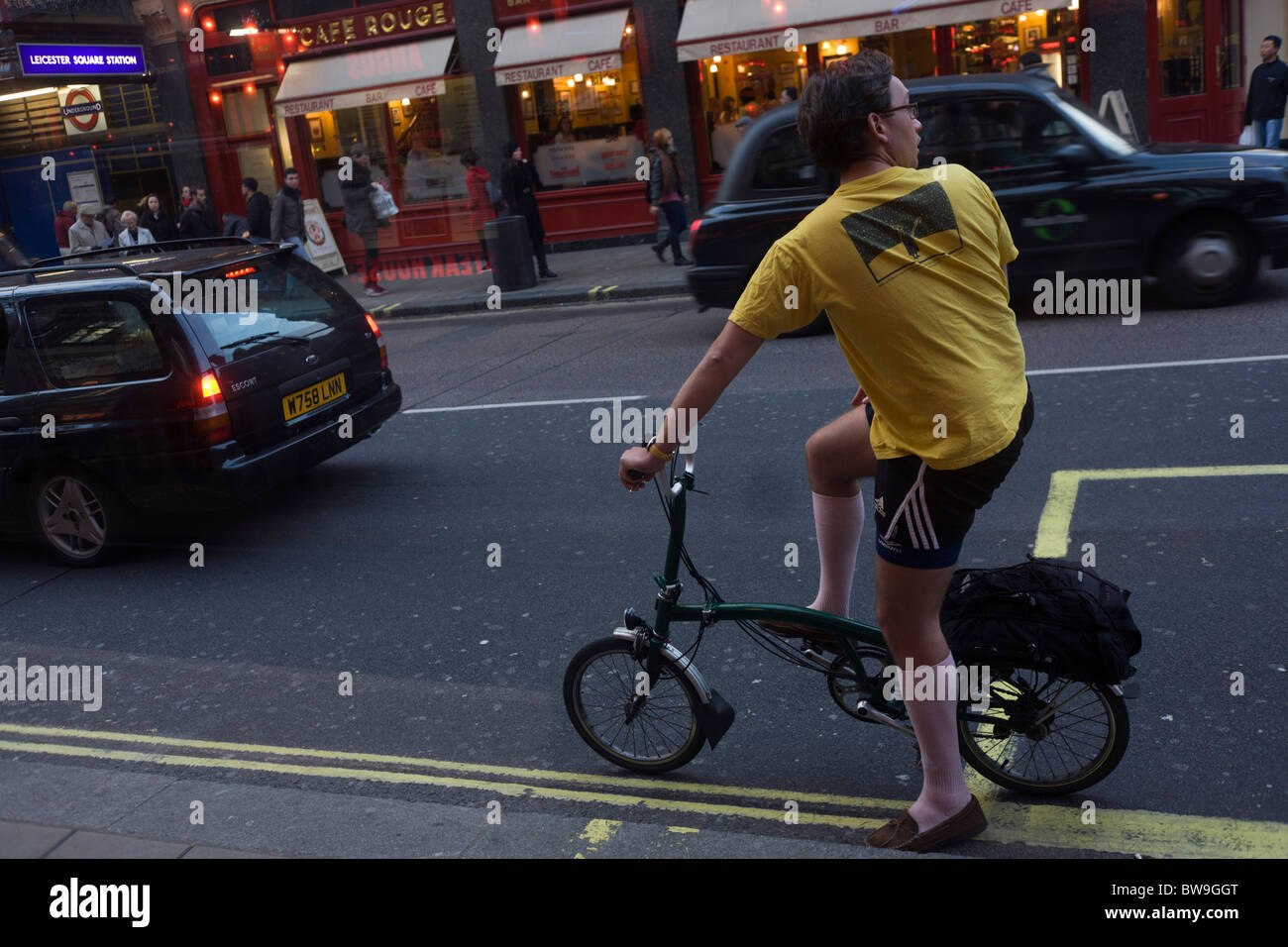 Shorts-wearing cyclist looks over shoulder before re-joining traffric ...