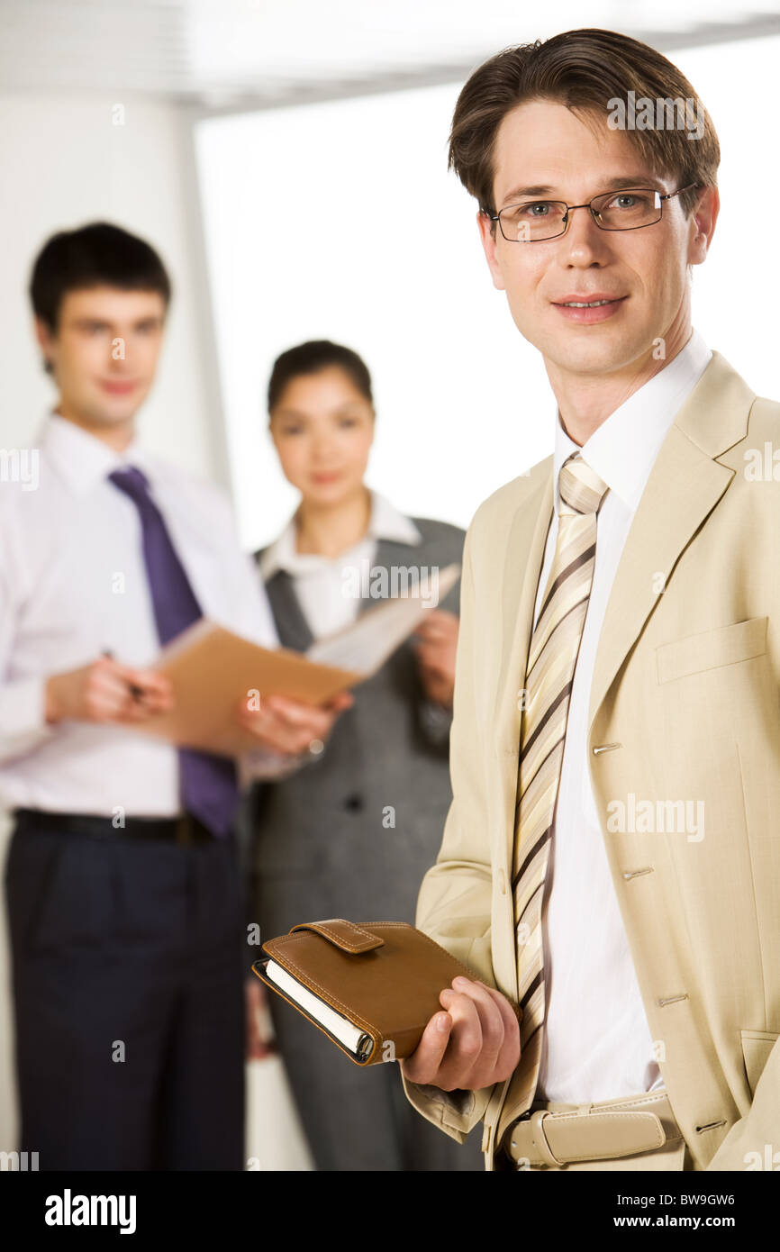 Vertical image of contemporary man holding his organizer in the office ...