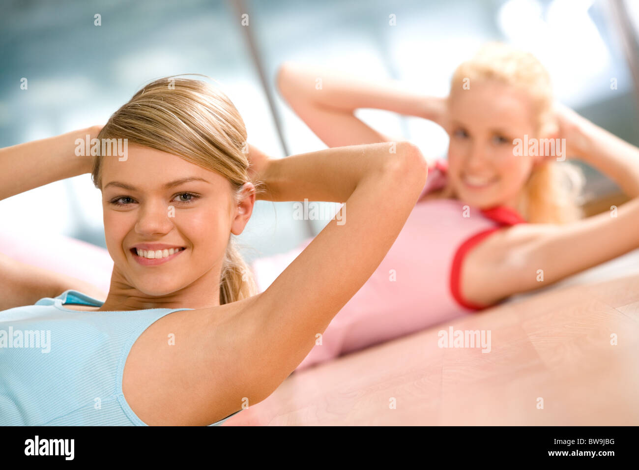 Photo of cheerful girls doing exercise on the floor of sport gym Stock ...