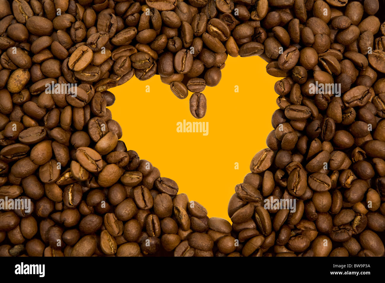 Backdrop of yellow heart shape inside coffee grains Stock Photo - Alamy