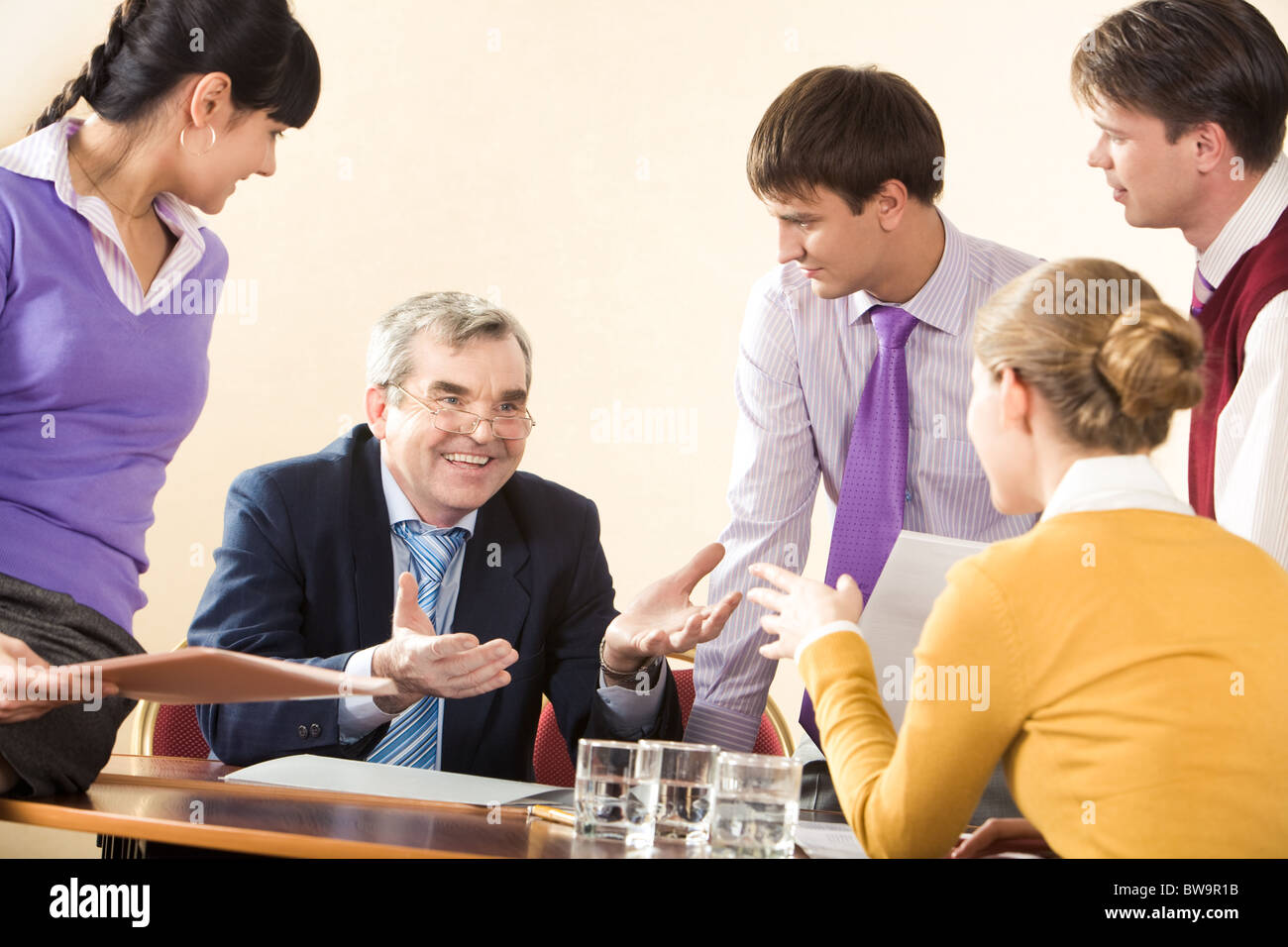 Group of successful managers communicating with senior boss at meeting ...